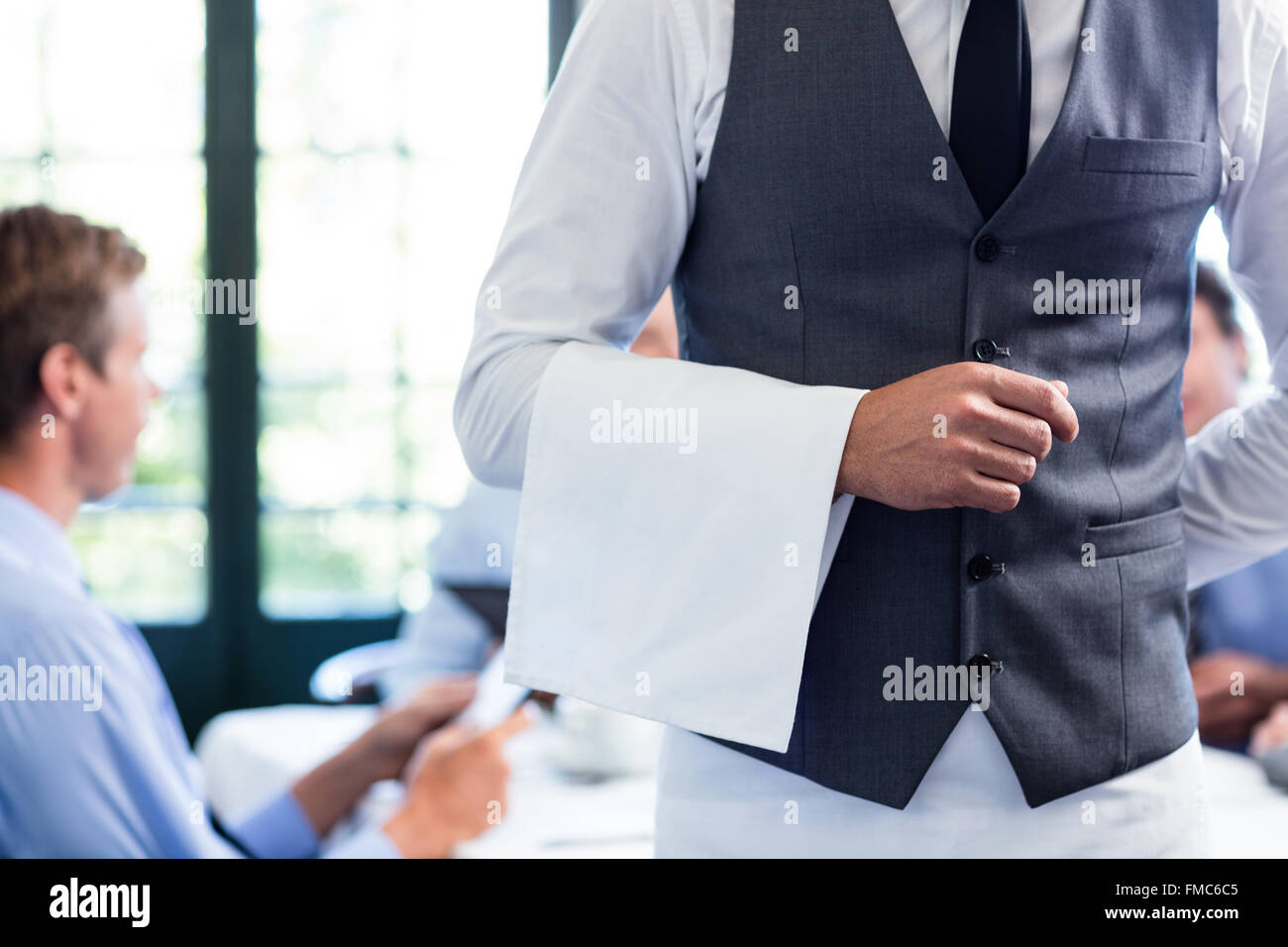 Close-up of waiter standing with napkin Stock Photo - Alamy