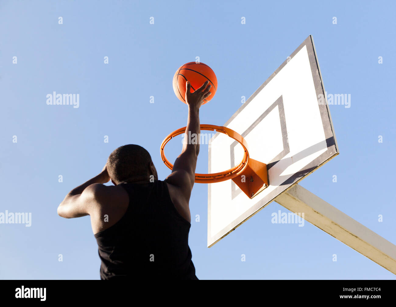 Basketball player jumping to dunk Stock Photo - Alamy