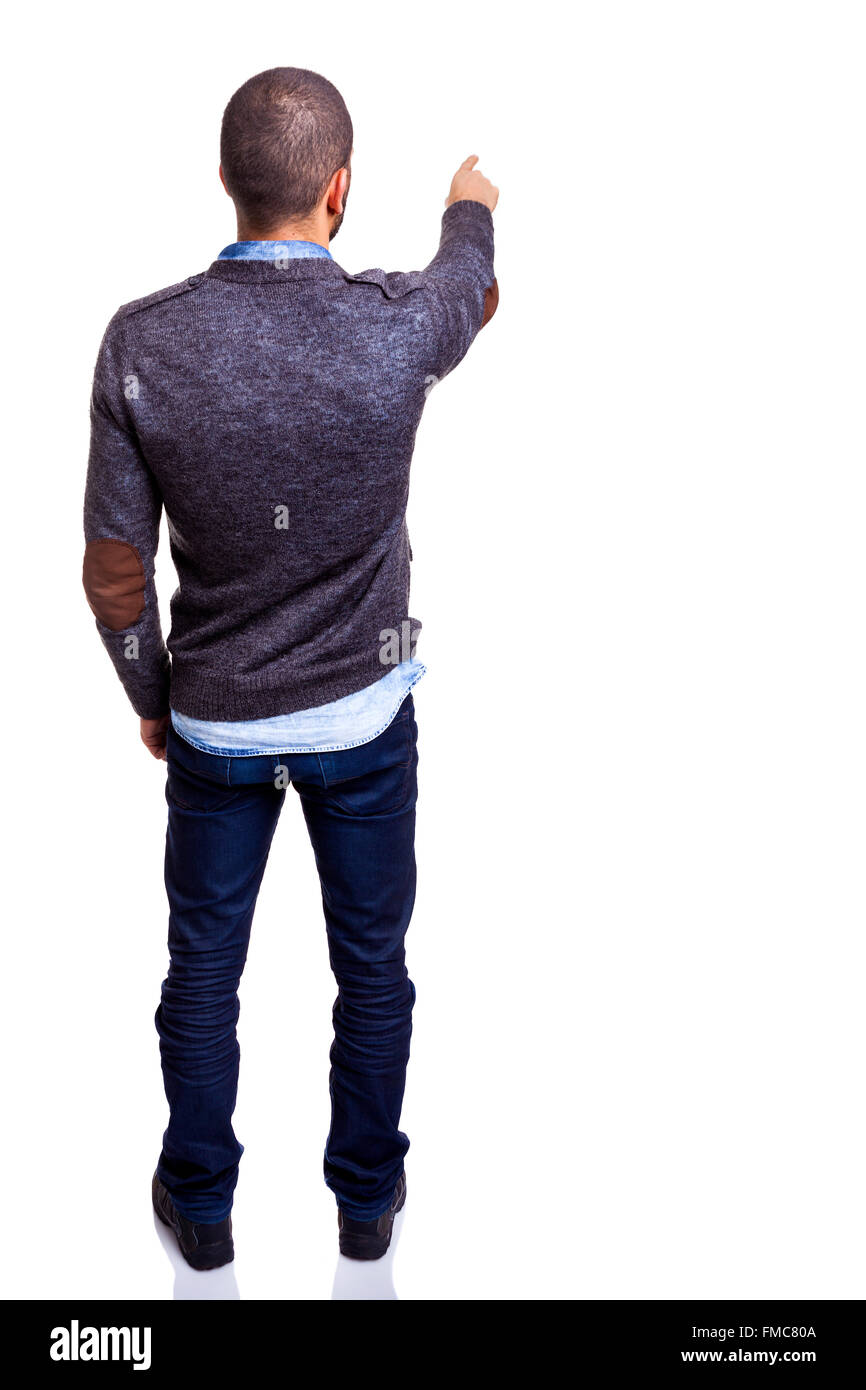 Casual man pointing to copyspace, isolated over a white background ...