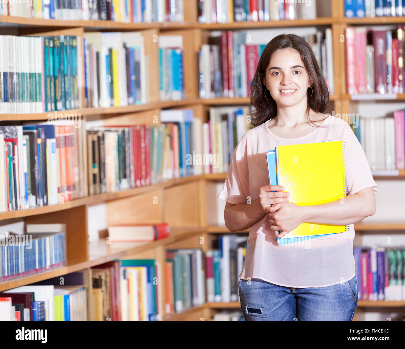 Cute female student holding notebooks at the university library Stock ...