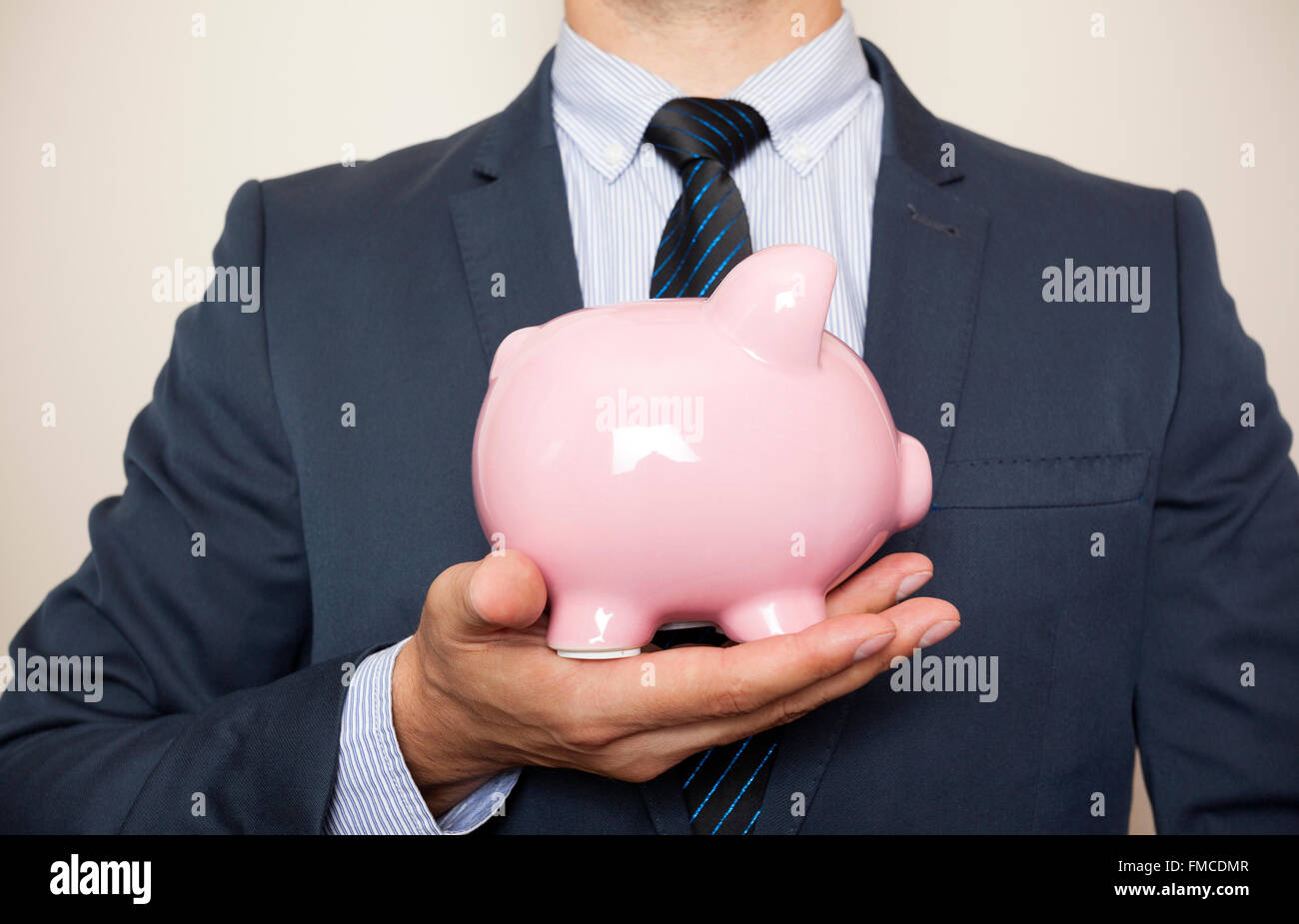 Business man holding a piggy banck Stock Photo - Alamy