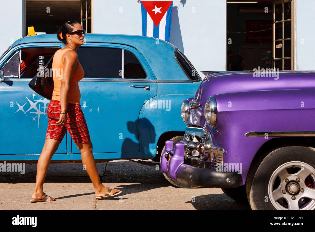 Cuba, Beautiful American before the Cuban flag Stock Photo - Alamy