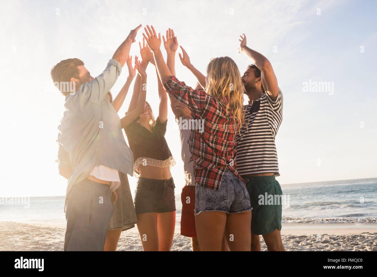 Happy friends giving high five Stock Photo - Alamy