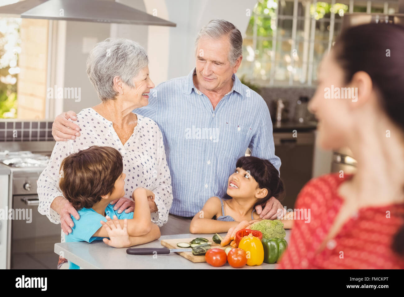 Happy family talking in kitchen Stock Photo - Alamy