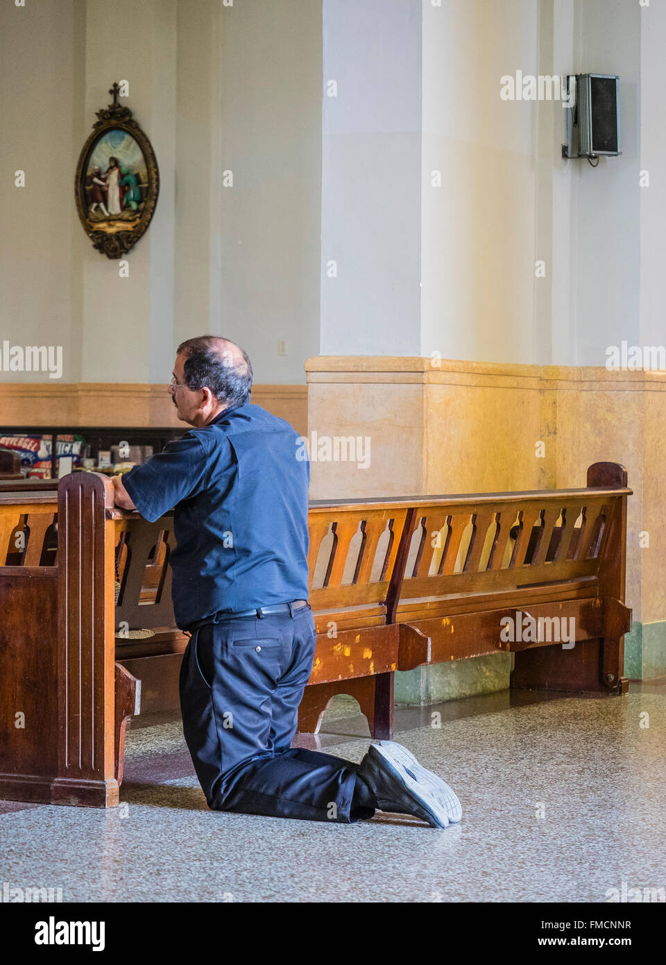 Cuban man kneeling in prayer in a church in Santiago de Cuba Stock ...
