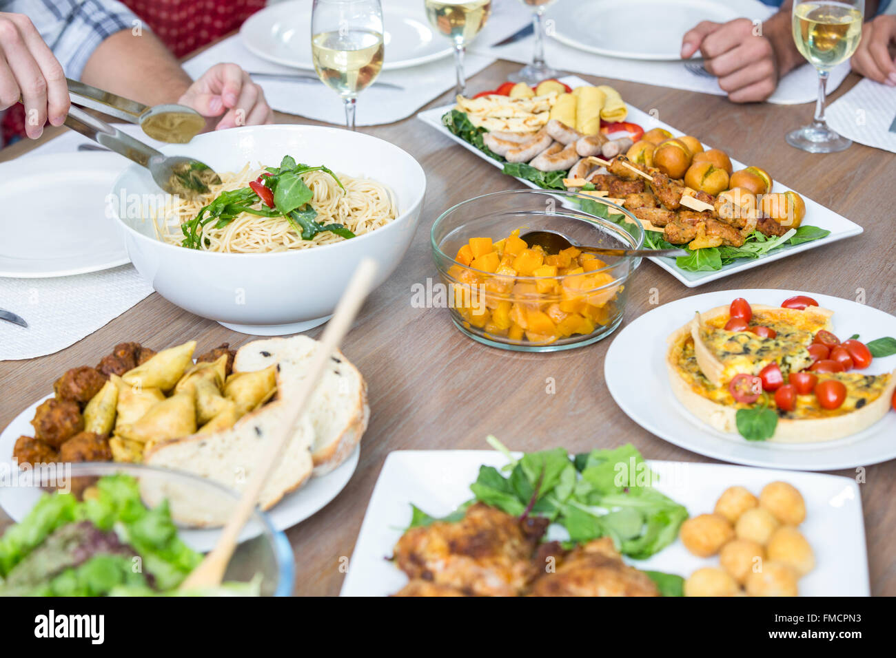 Cropped image of people with food served on table Stock Photo - Alamy