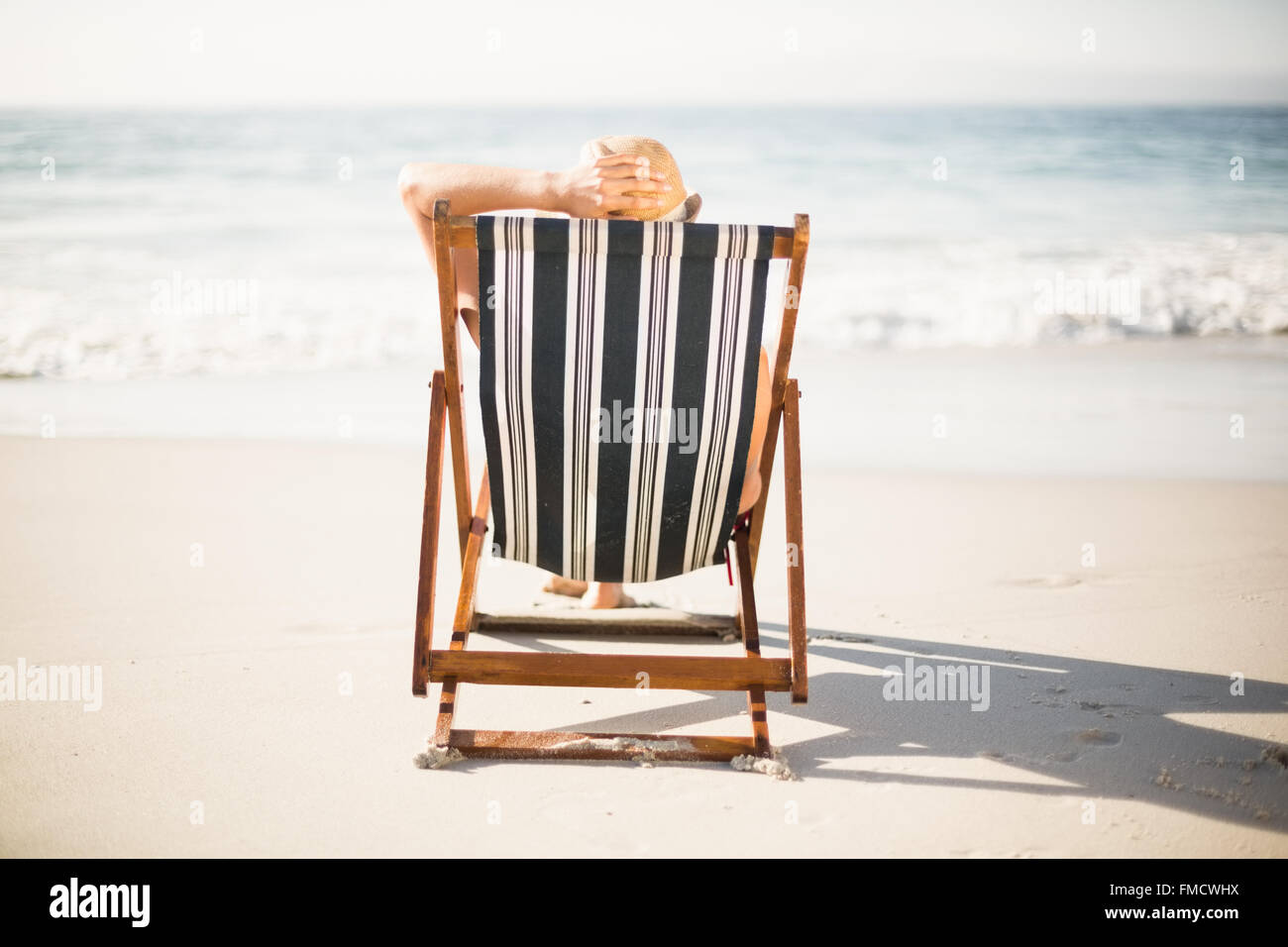 Rear view of woman relaxing on the beach Stock Photo - Alamy