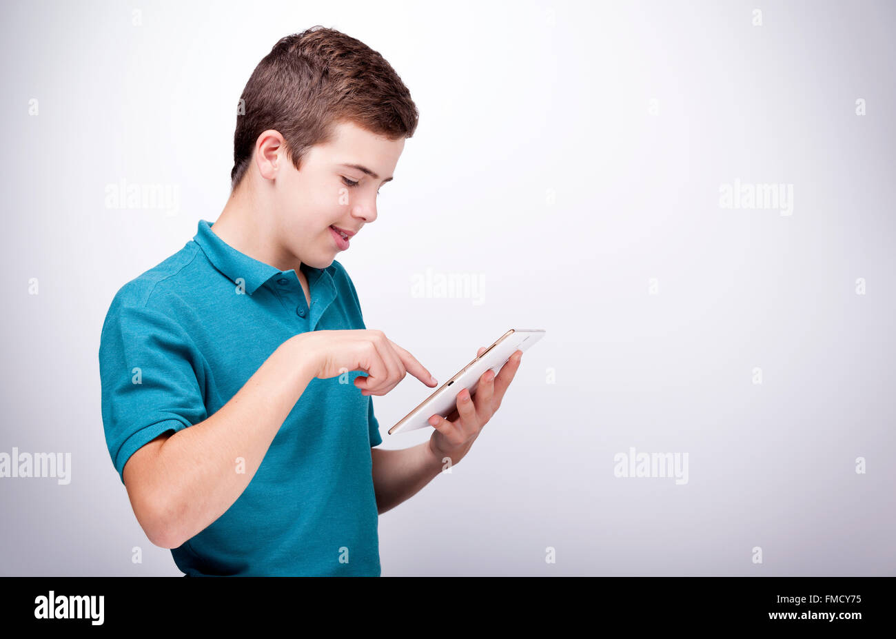 Boy with a digital tablet on grey background Stock Photo - Alamy