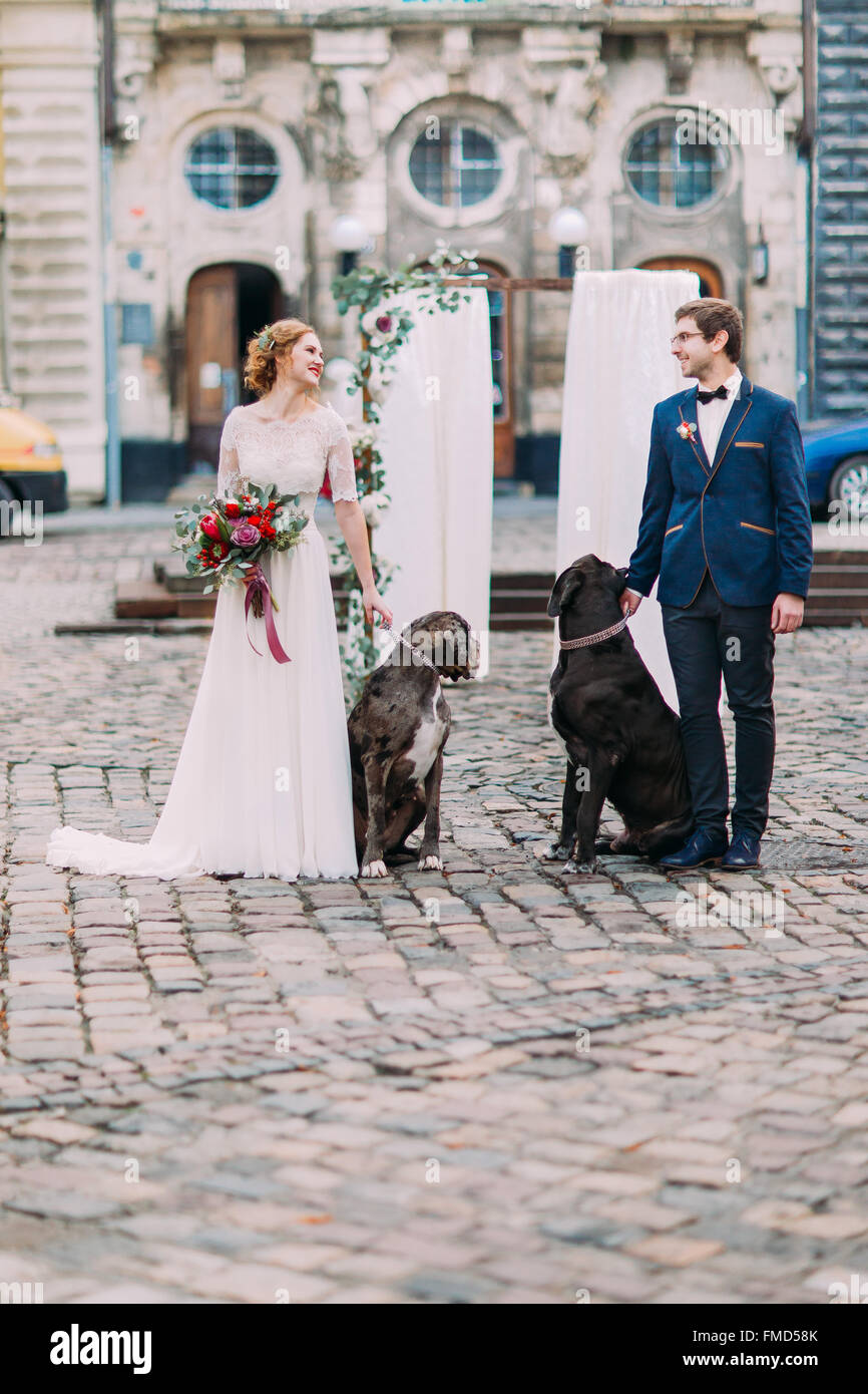 Stylish young groom and bride lovingly looking on each other and ...