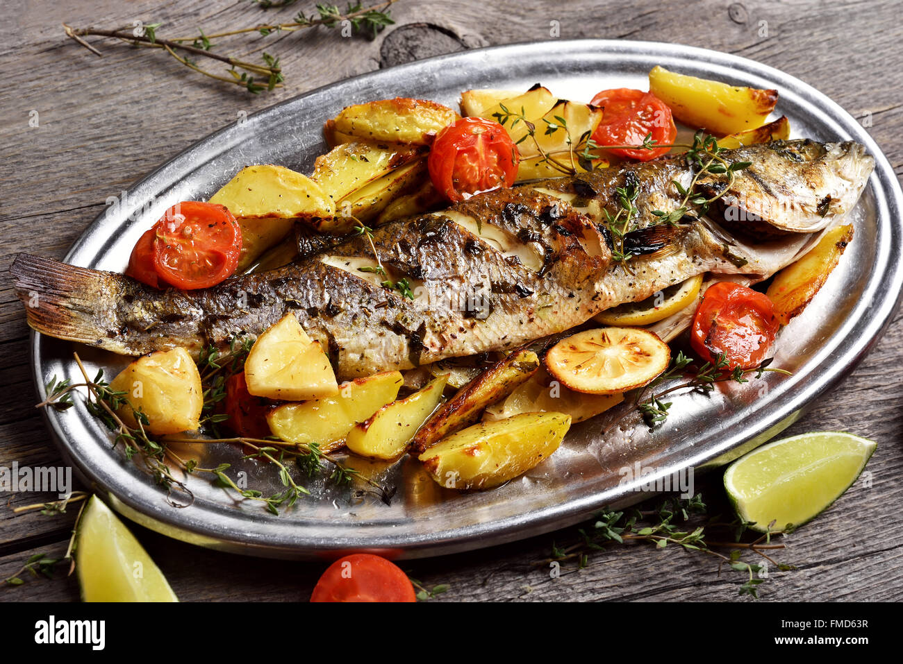 Grilled fish with baked potato wedges Stock Photo - Alamy