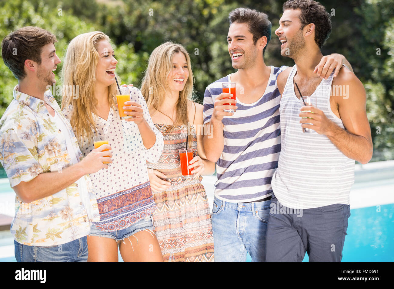 Group of happy friends having juice near pool Stock Photo - Alamy