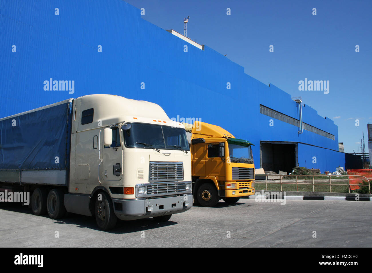 lorries on a background of a dark blue warehouse Stock Photo - Alamy