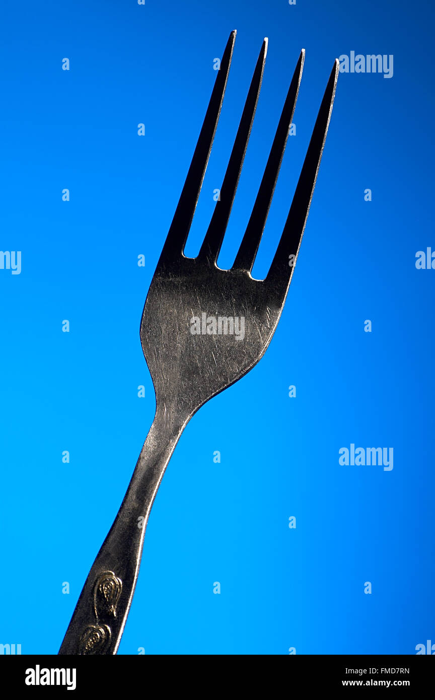 One fork on a dark blue background Stock Photo - Alamy