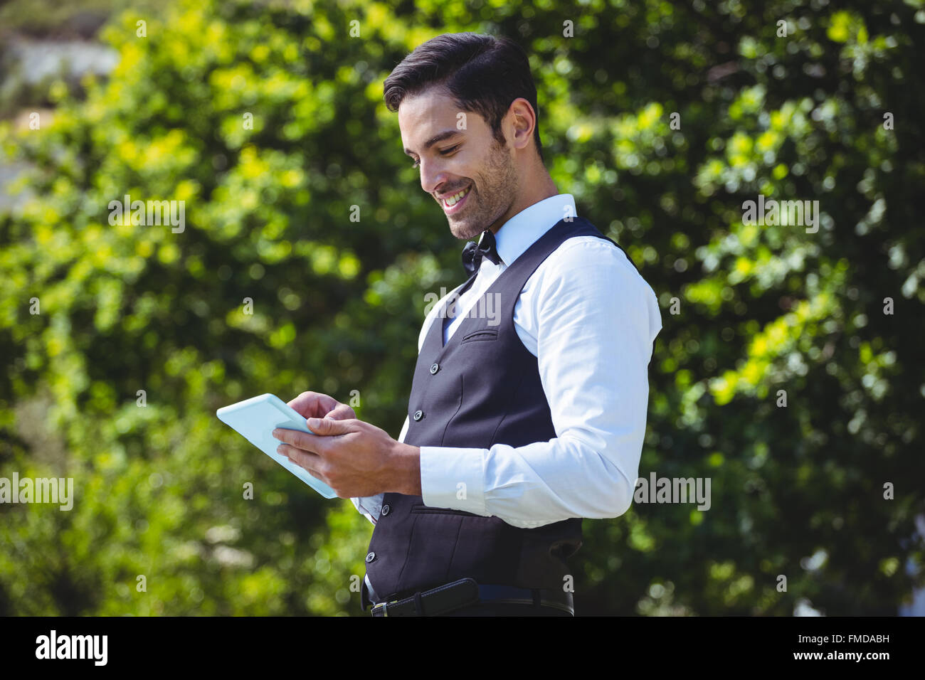 Handsome waiter using tablet computer Stock Photo - Alamy