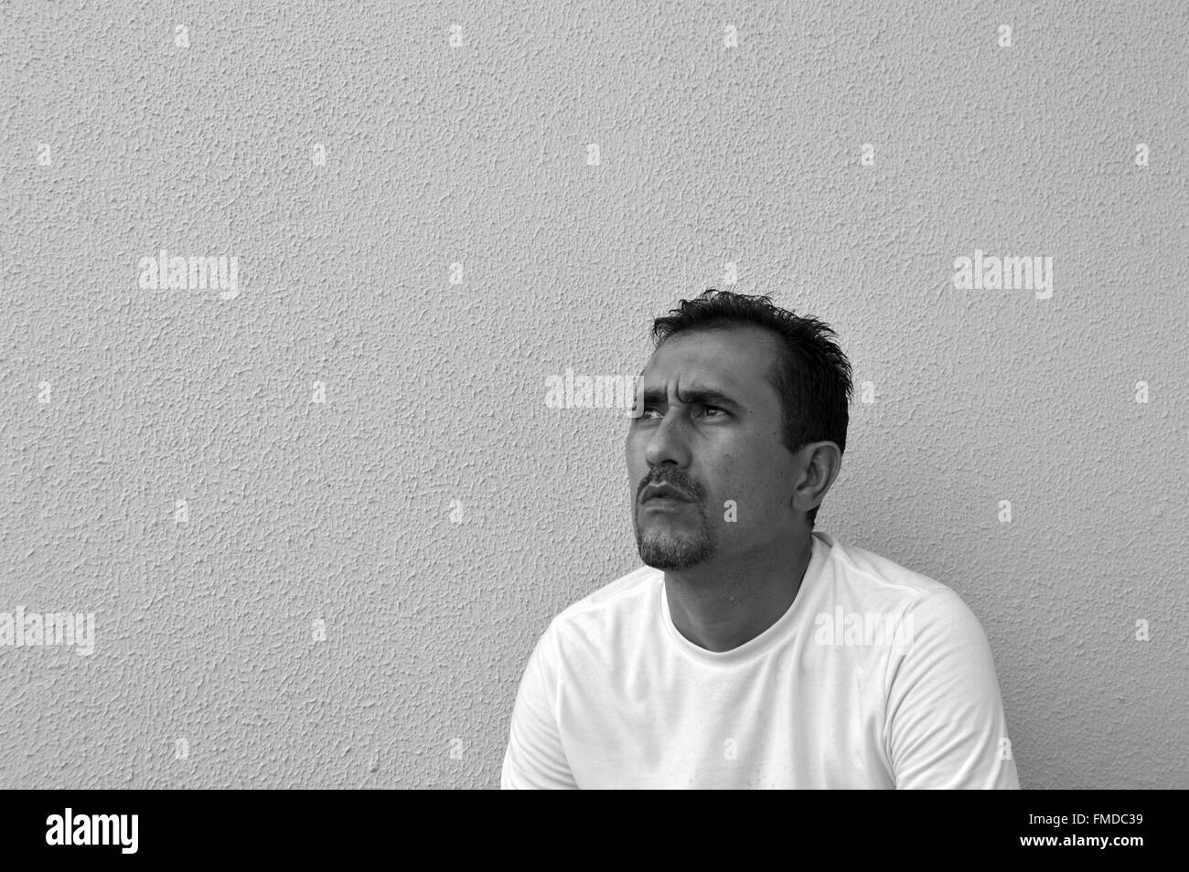 Sad Latino Man Thinking Textured Wall Background Stock Photo - Alamy