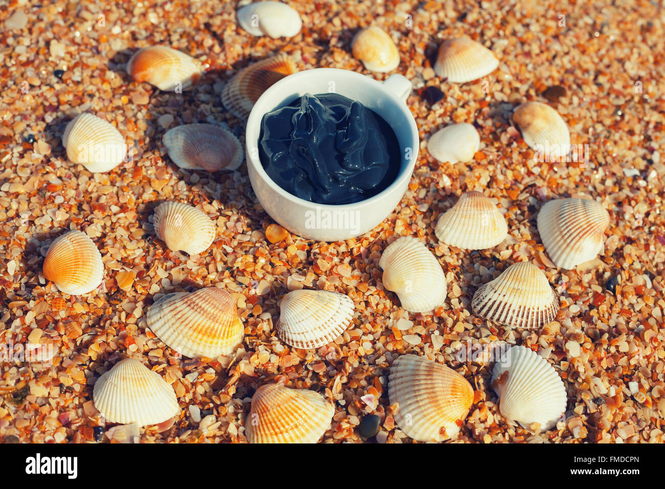 Dead sea mud for spa treatments in a cup on the beach with shell Stock ...