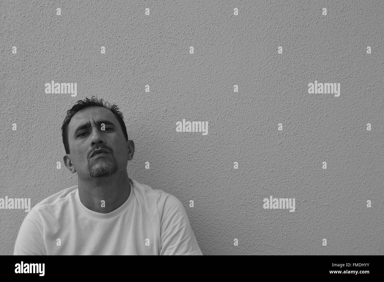 Sad Latino Man Thinking Textured Wall Background Stock Photo - Alamy