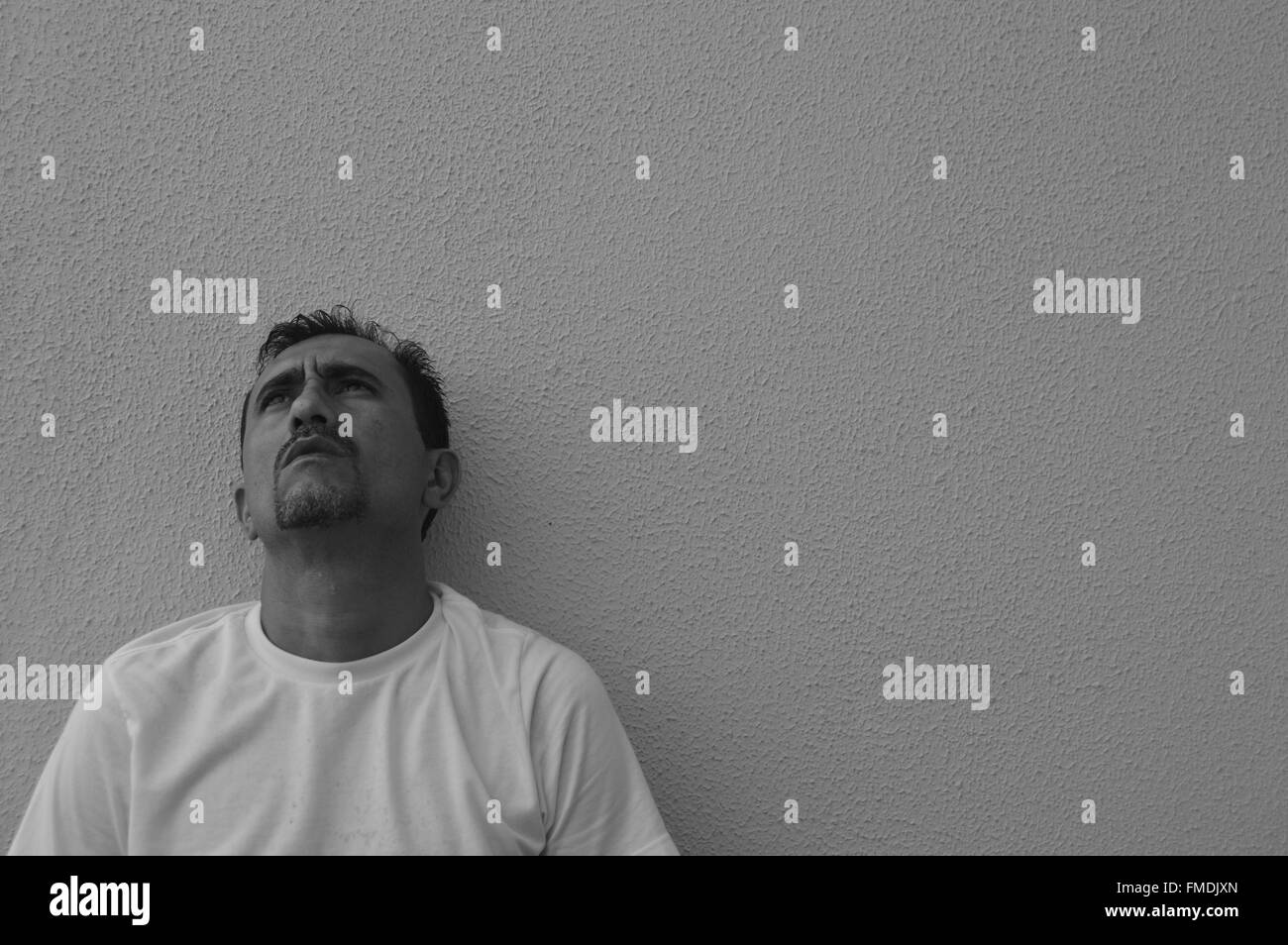 Sad Latino Man Thinking Textured Wall Background Stock Photo - Alamy