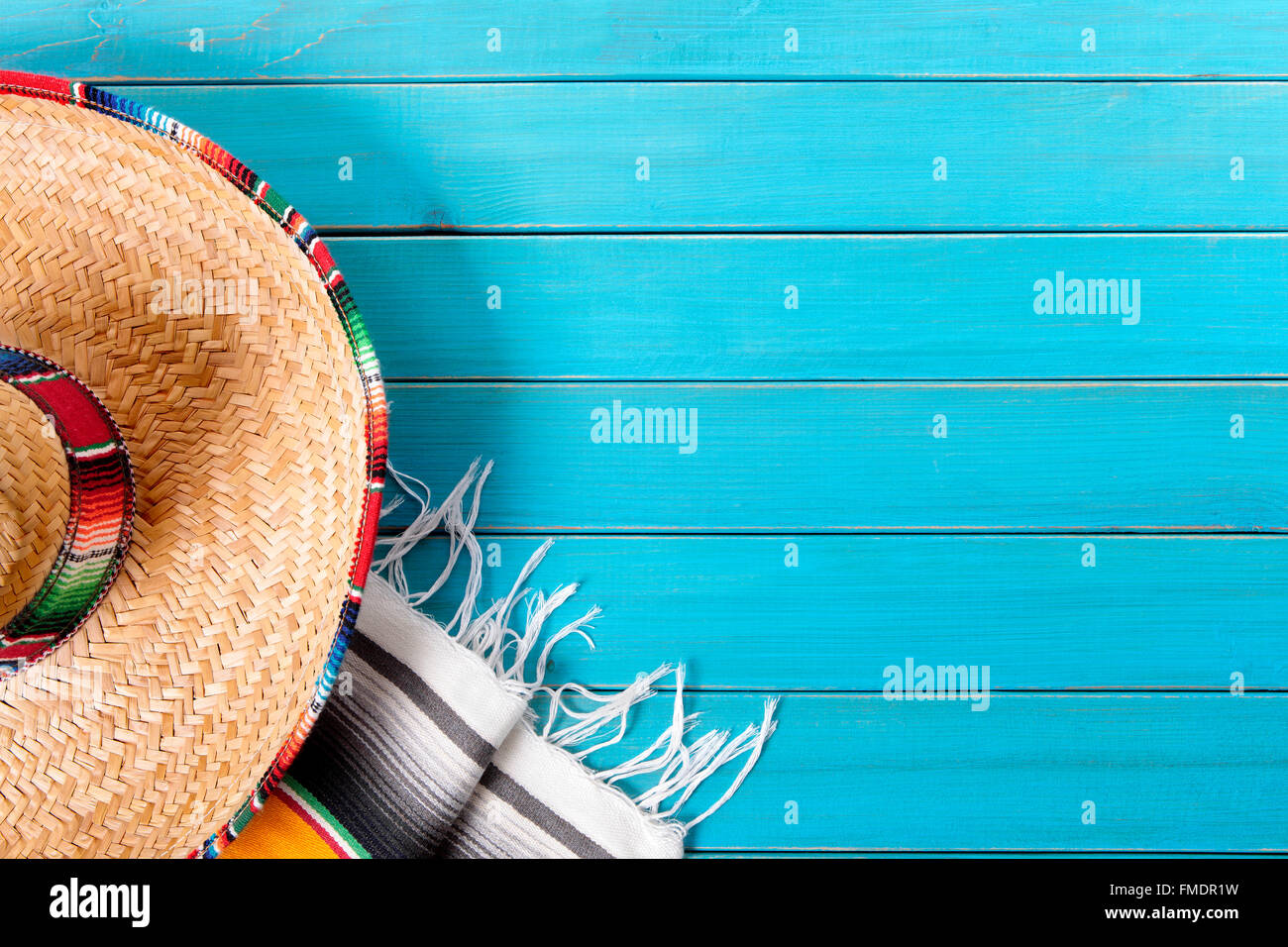 Mexican sombrero and traditional serape blanket laid on an old blue ...