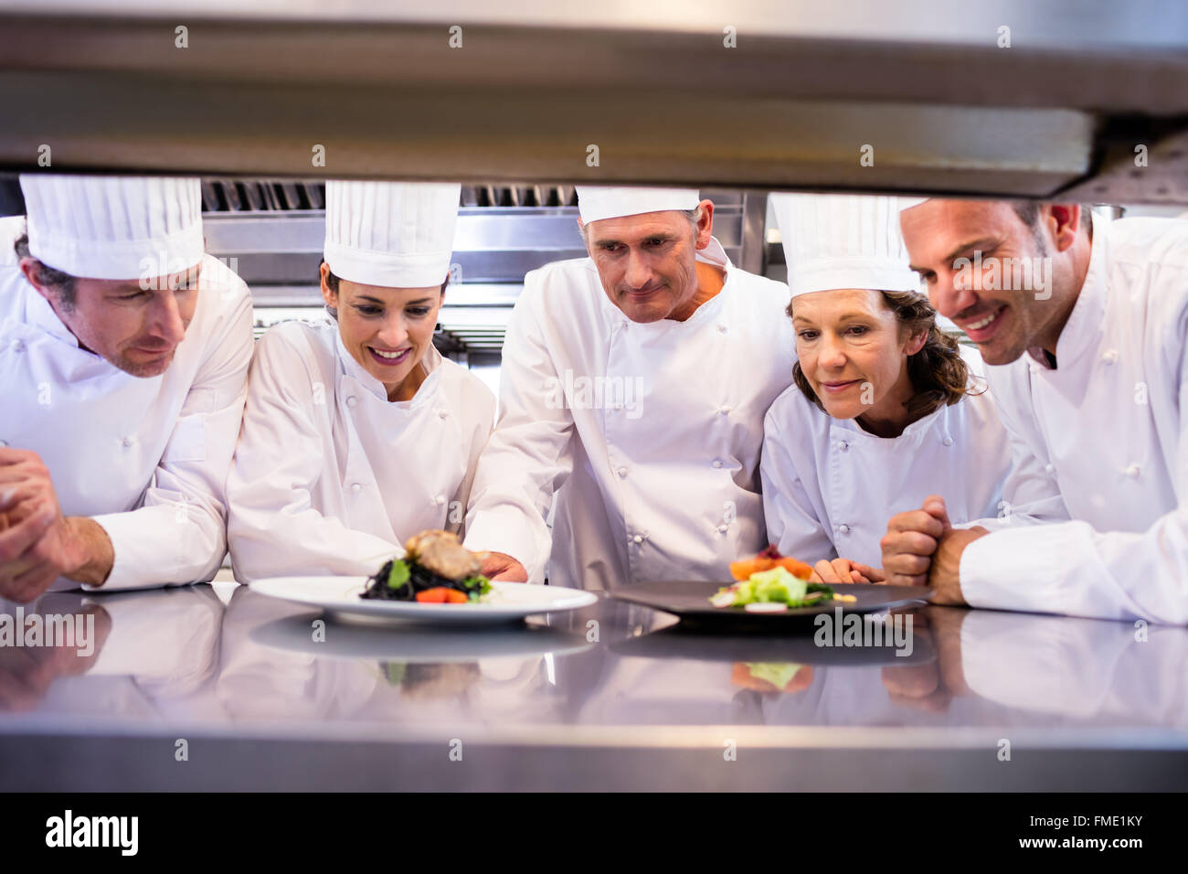 Chefs looking at the dish prepared by them Stock Photo - Alamy