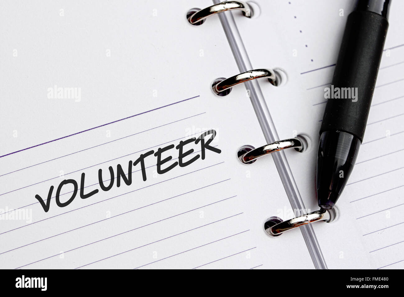 Volunteer word written on paper Stock Photo - Alamy