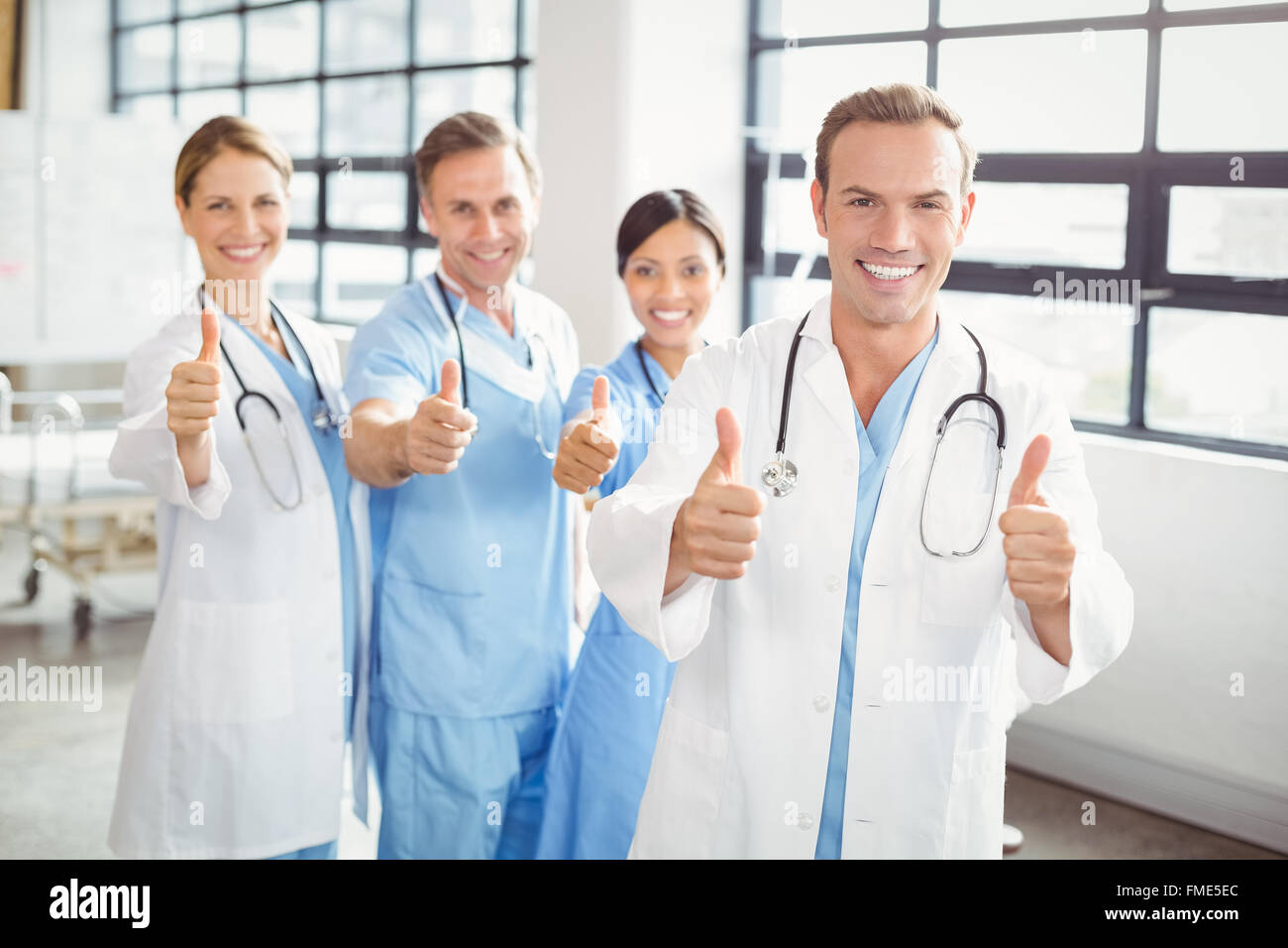 Medical team putting their thumbs up and smiling Stock Photo - Alamy