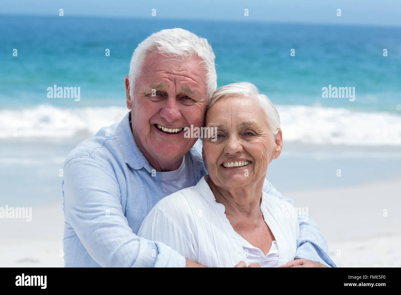 Senior couple embracing with arms around Stock Photo - Alamy