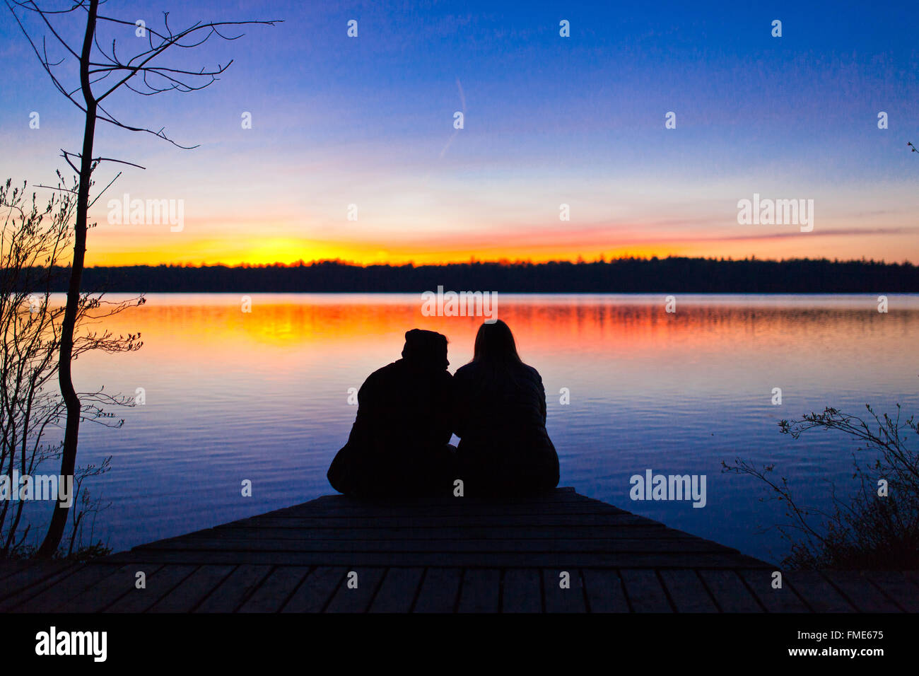 lovers sitting in front of a lake, watching the beautiful sunset Stock ...