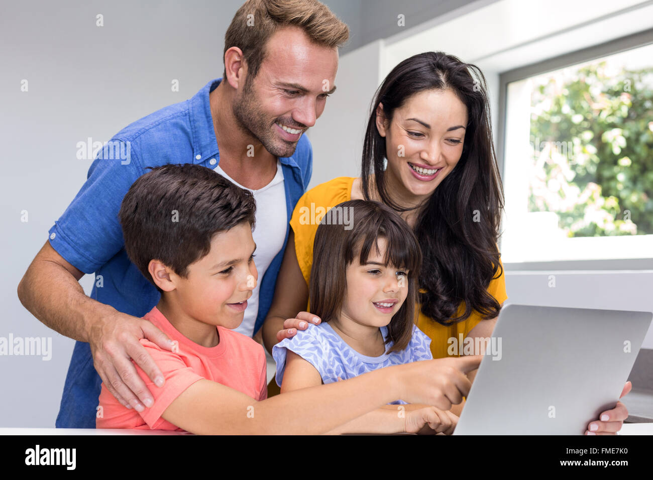Happy family interacting using laptop Stock Photo - Alamy