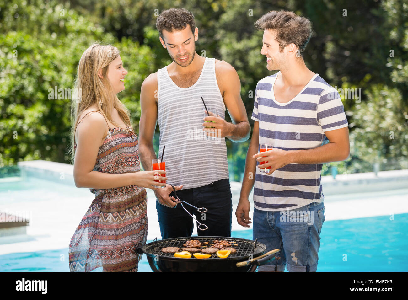 Happy friends preparing barbecue near pool Stock Photo - Alamy