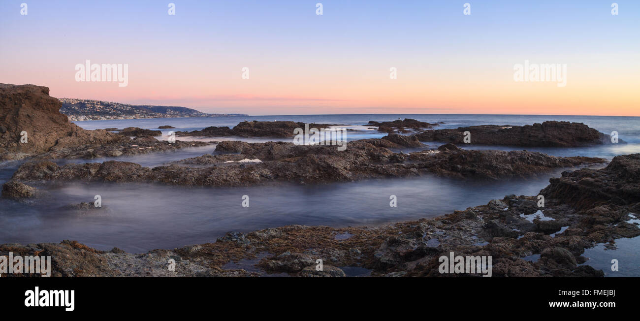 Long exposure of sunset over rocks, giving a mist like effect over ...