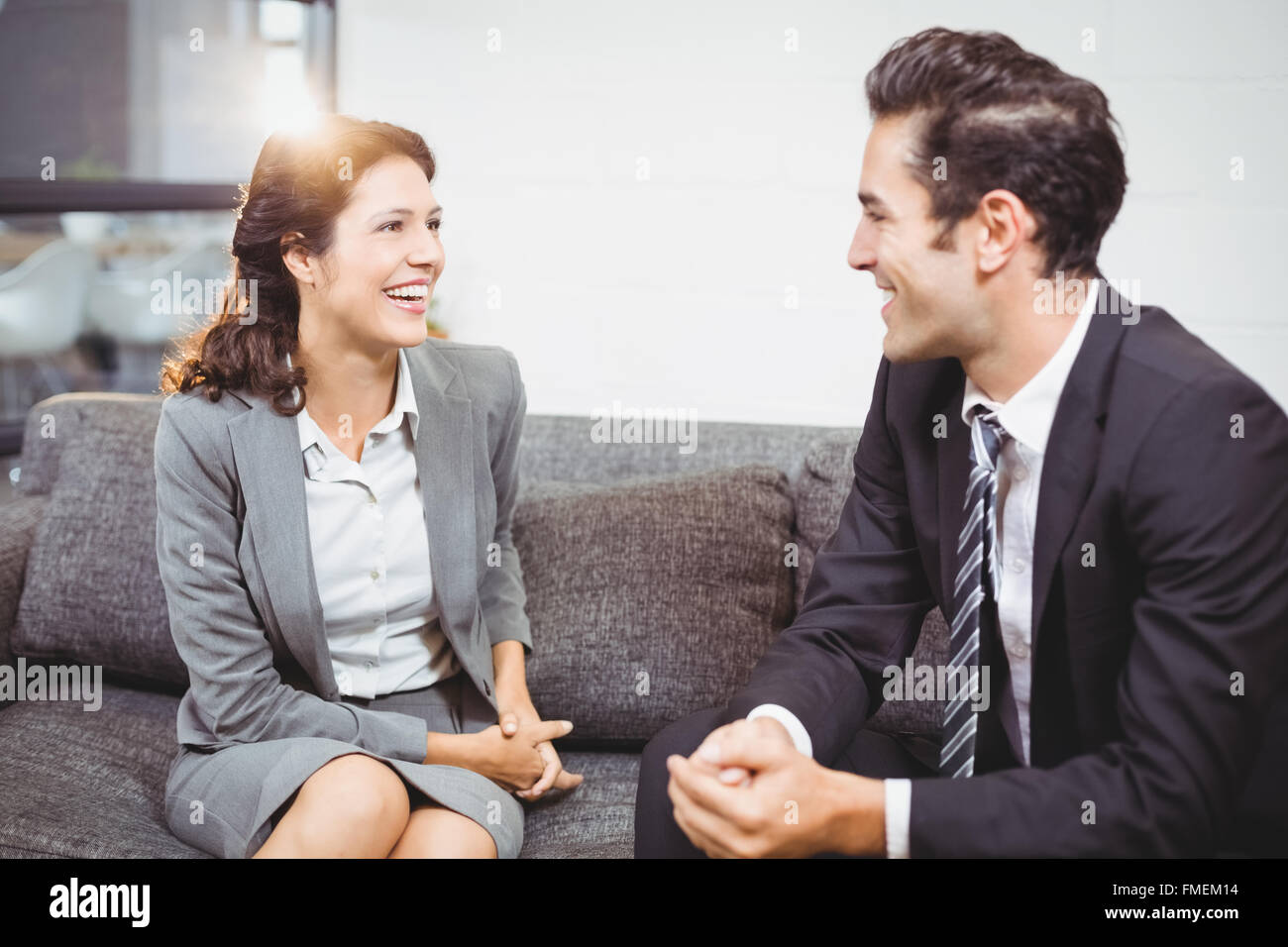 Smiling business people sitting on sofa Stock Photo - Alamy