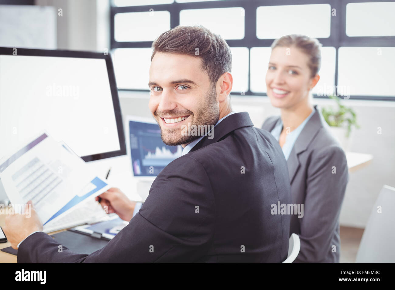 Happy business people working at computer desk Stock Photo - Alamy
