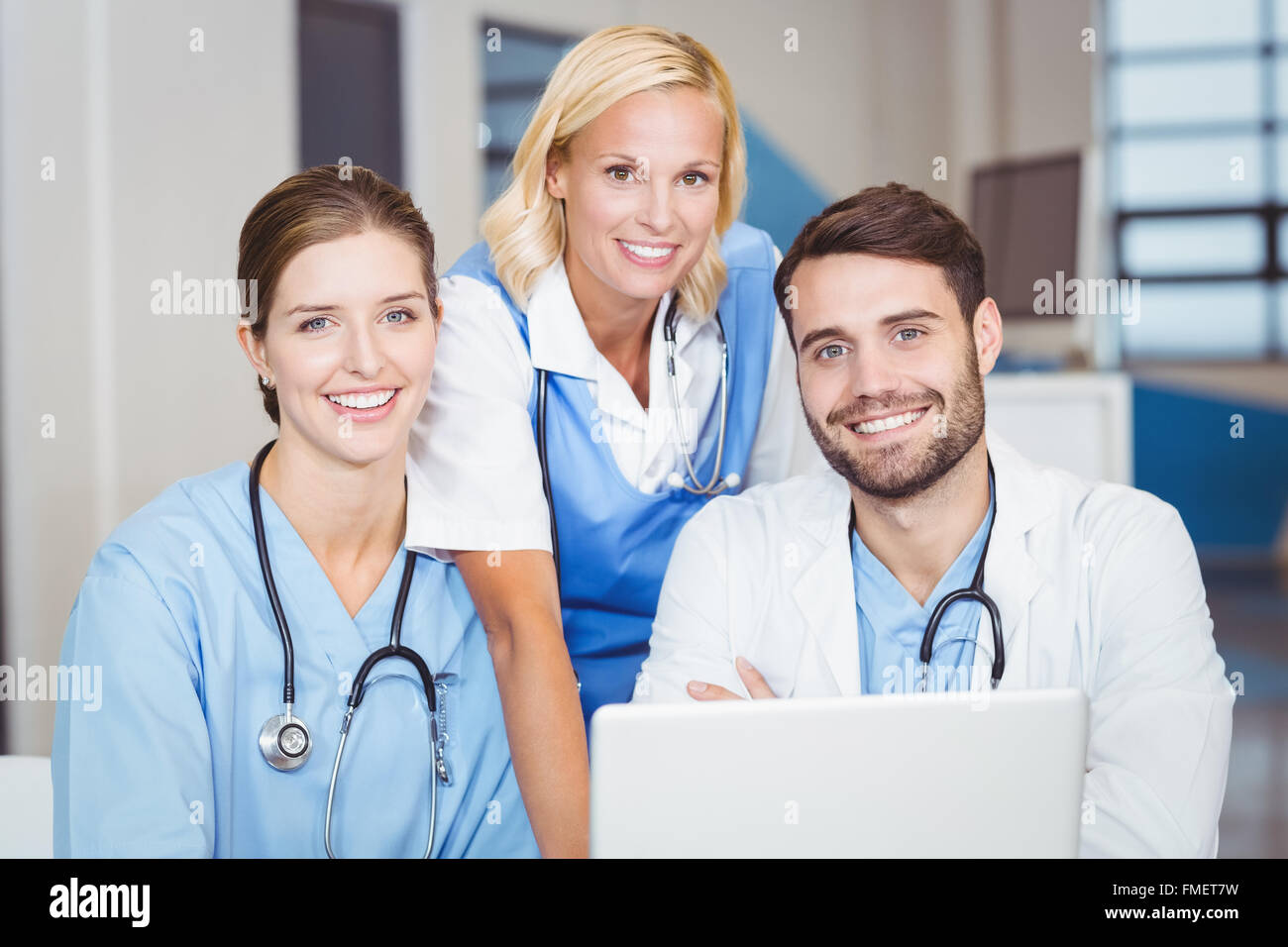 Portrait of happy doctor team at desk Stock Photo - Alamy