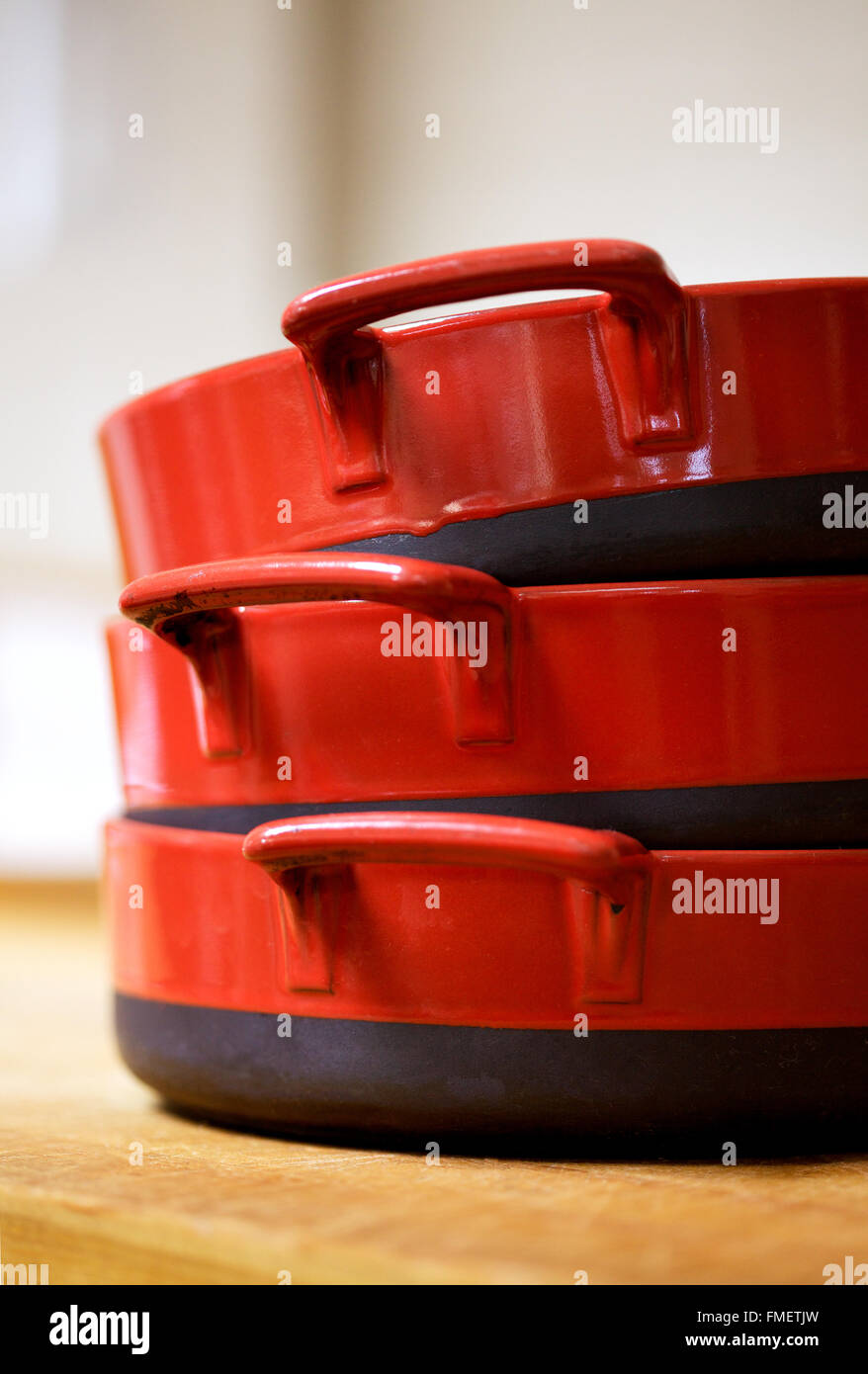 Stack of three red enamel pans with handles Stock Photo - Alamy
