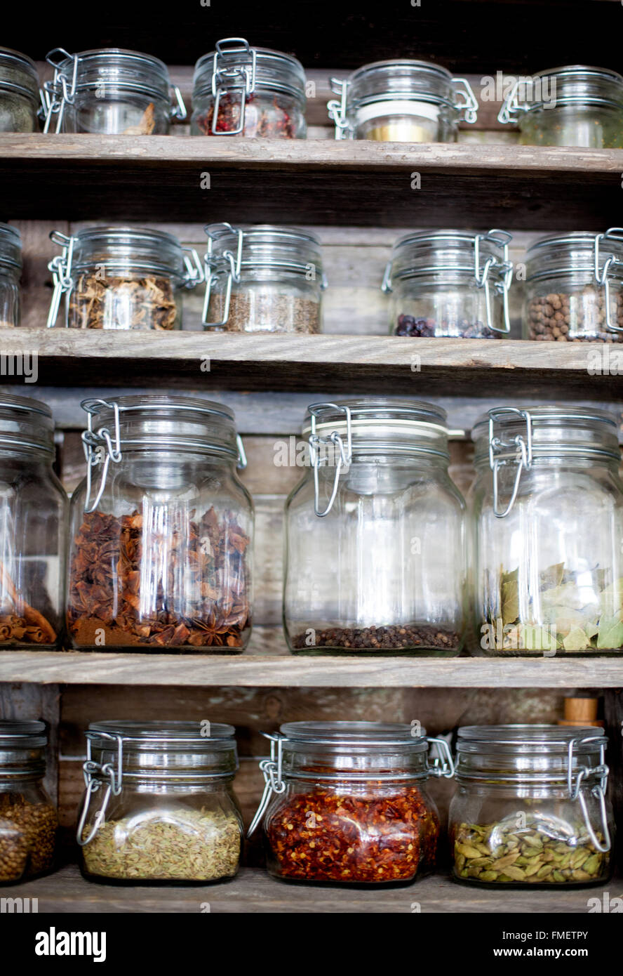 Spice jars of various sizes on a wooden shelf Stock Photo - Alamy