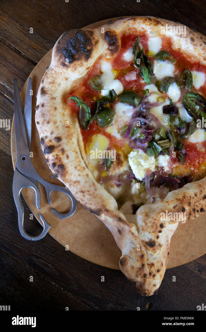 A Neapolitan style pizza shot from above with scissors on the side ...