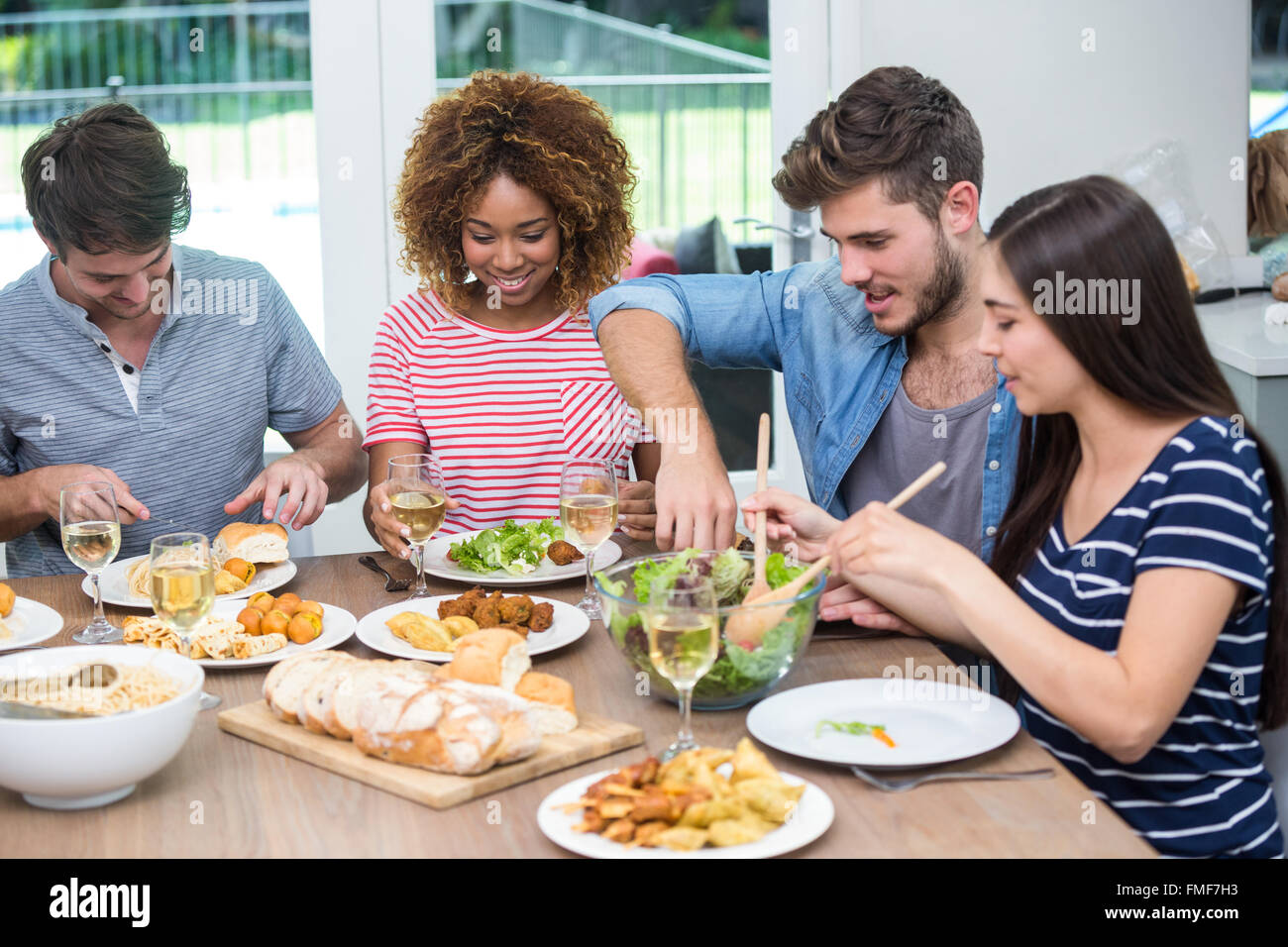 Young friends having meal at table Stock Photo - Alamy