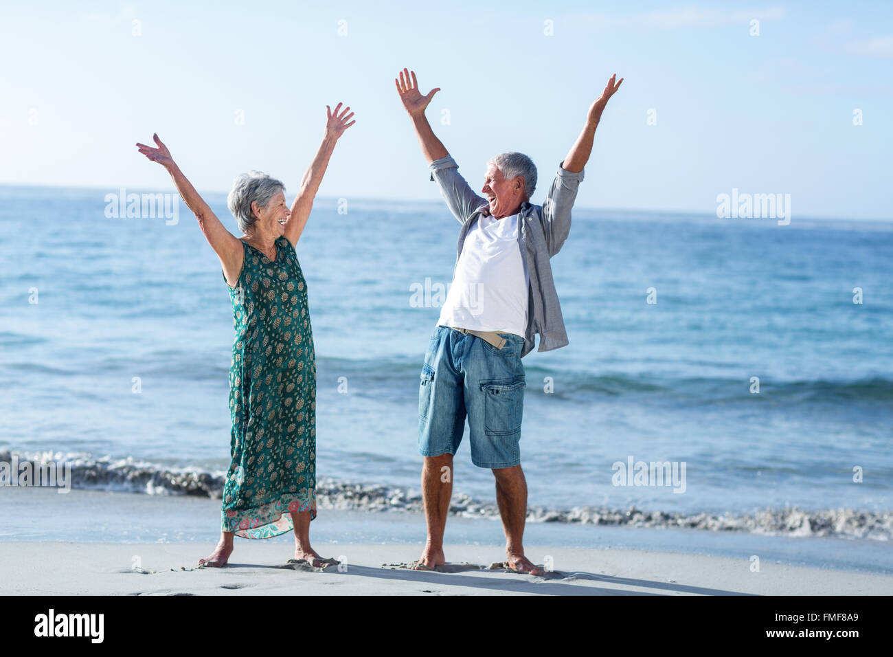 Senior couple raising arms Stock Photo - Alamy