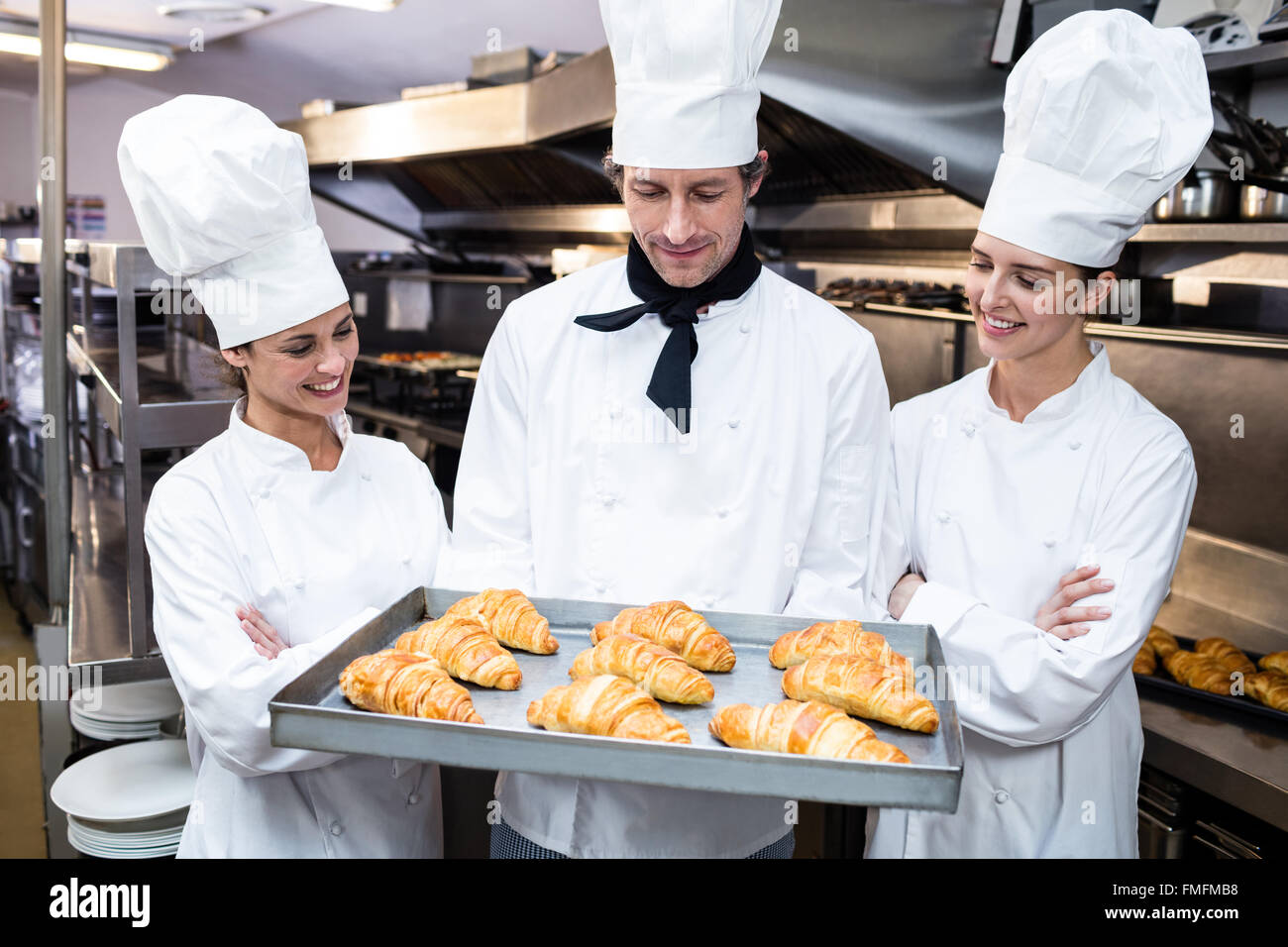 Three chefs holding a tray of baked croissant Stock Photo - Alamy