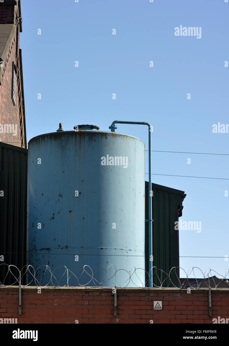 Storage tank behind razor wire topped fence in bury lancashire uk Stock ...