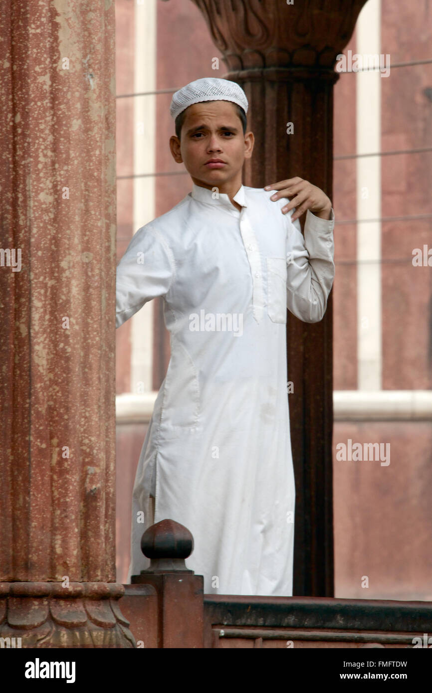 Boy in white stretching next to pillar Stock Photo - Alamy