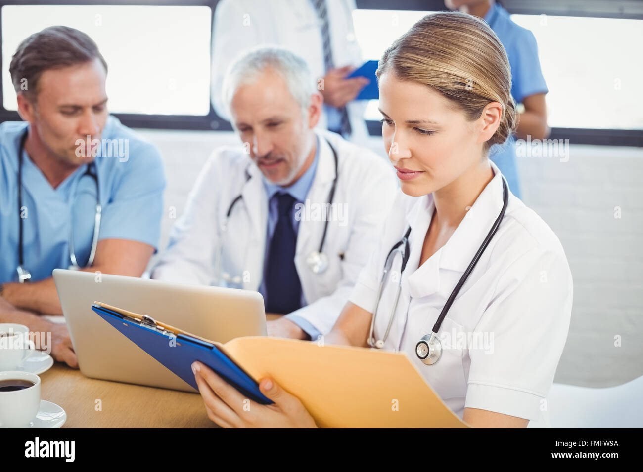 Female doctor looking at medical report Stock Photo - Alamy