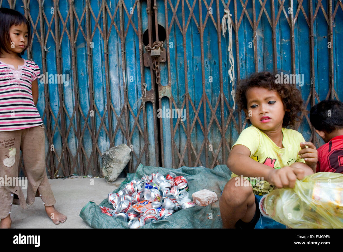 Young children who are scavengers are smashing aluminum cans on a city ...
