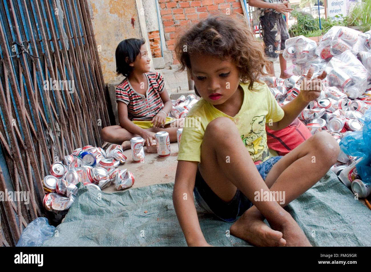 Young children who are scavengers are smashing aluminum cans on a city ...