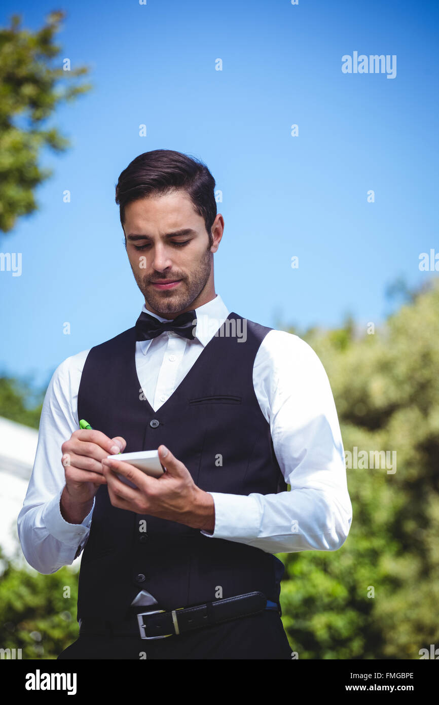 Handsome waiter writing the order Stock Photo - Alamy