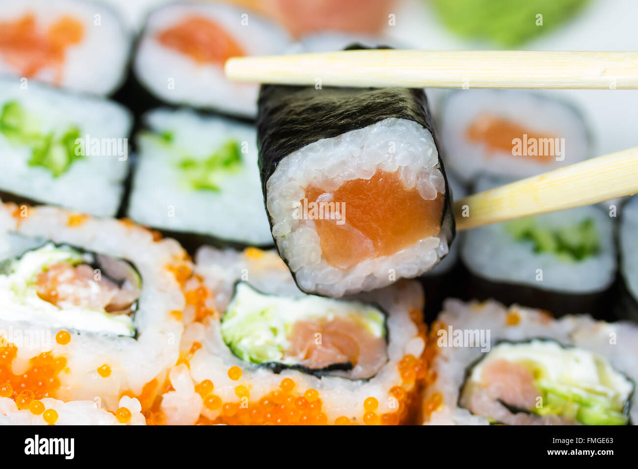 Closeup view of a set of maki sushi. One piece of sushi is in the sushi ...