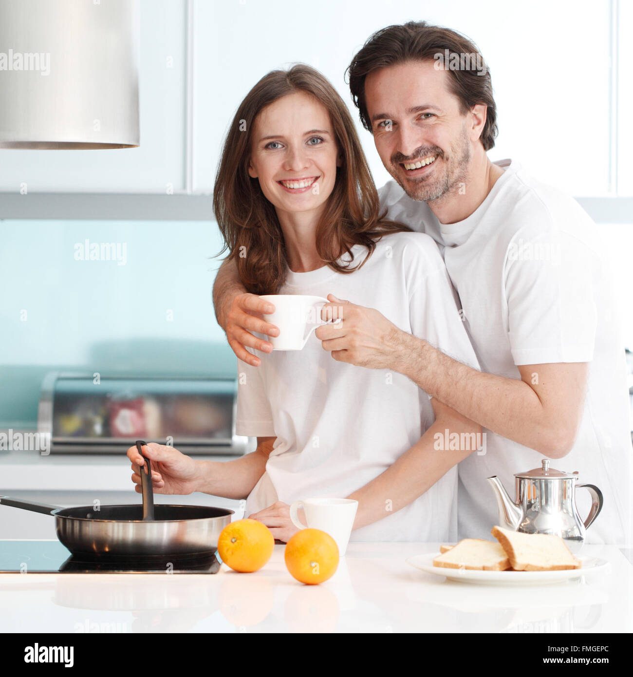Happy couple cooking breakfast together in the kitchen Stock Photo - Alamy
