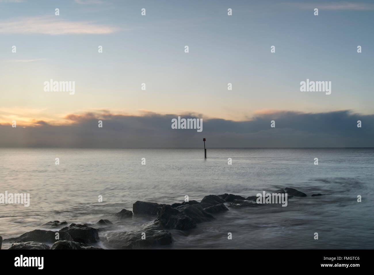Beautiful sunrise landscape over rocks in sea Stock Photo - Alamy
