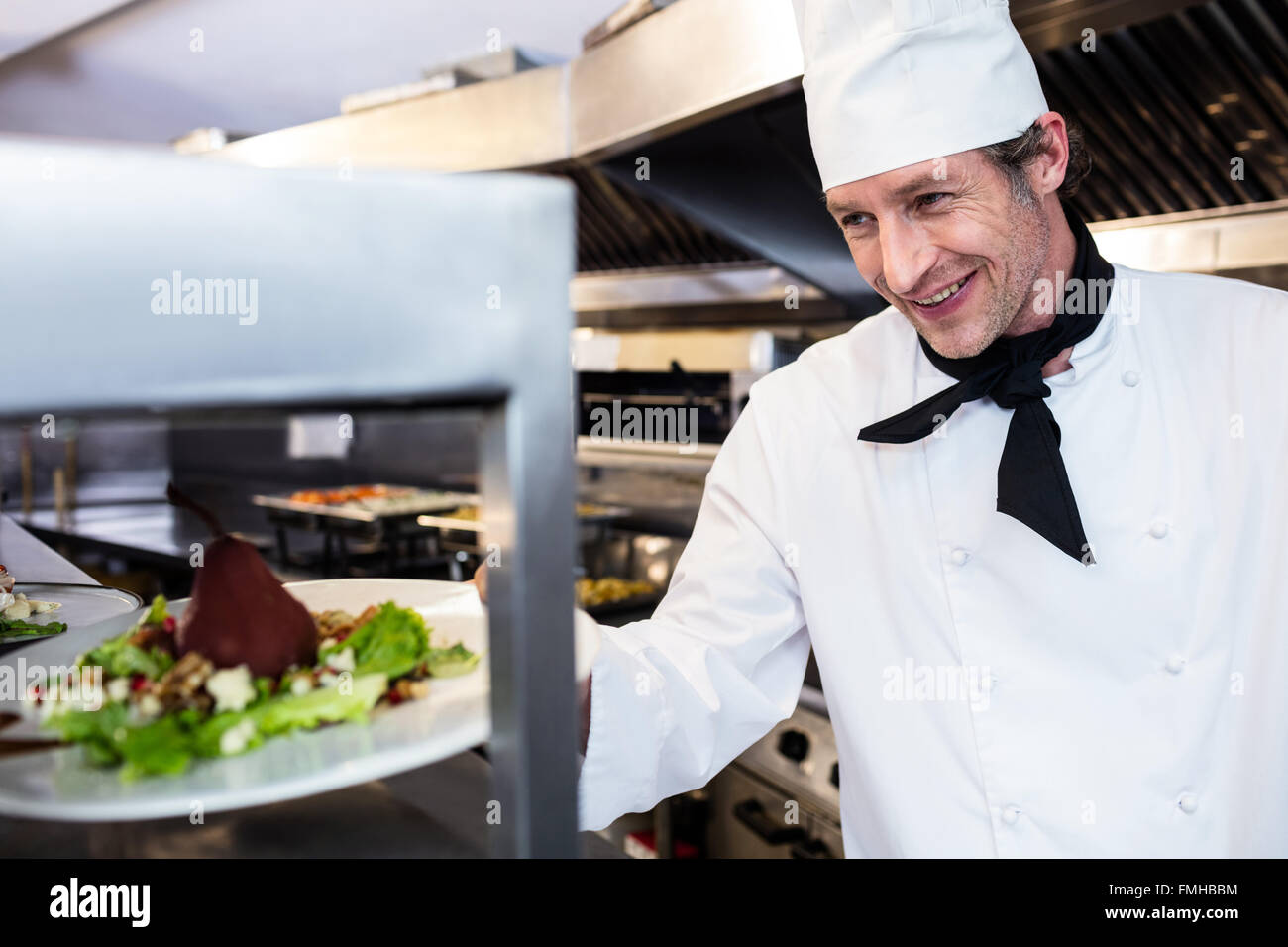 Chef handing dinner plate through order station Stock Photo - Alamy
